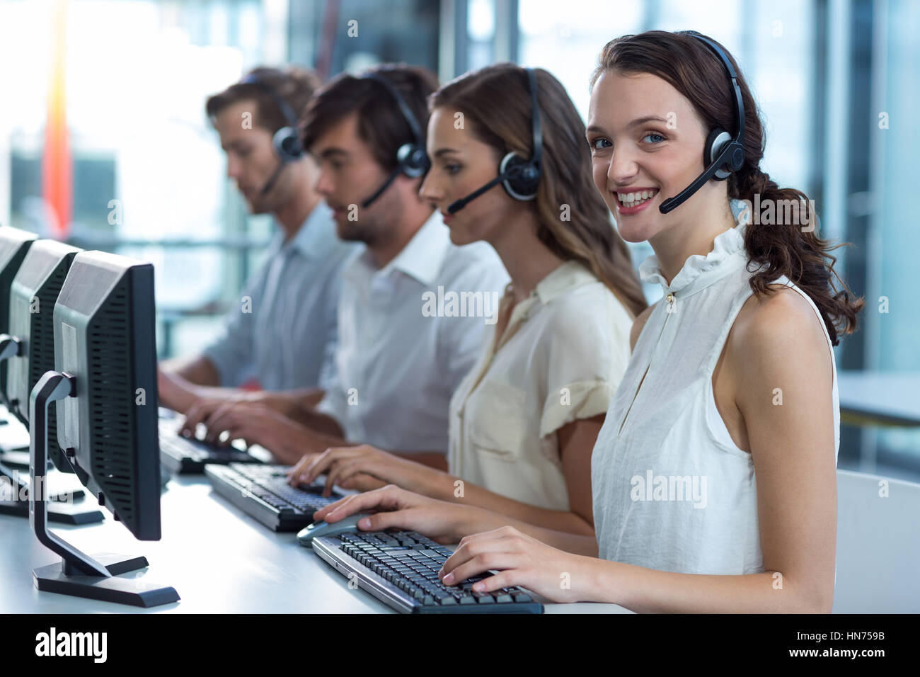 Business executives with headsets using computer in office Stock Photo ...