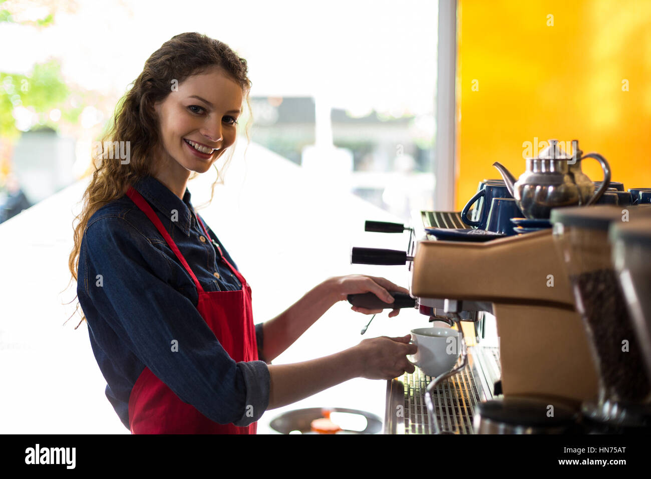 Portrait of smiling waitress making cup of coffee at cafe Stock Photo ...