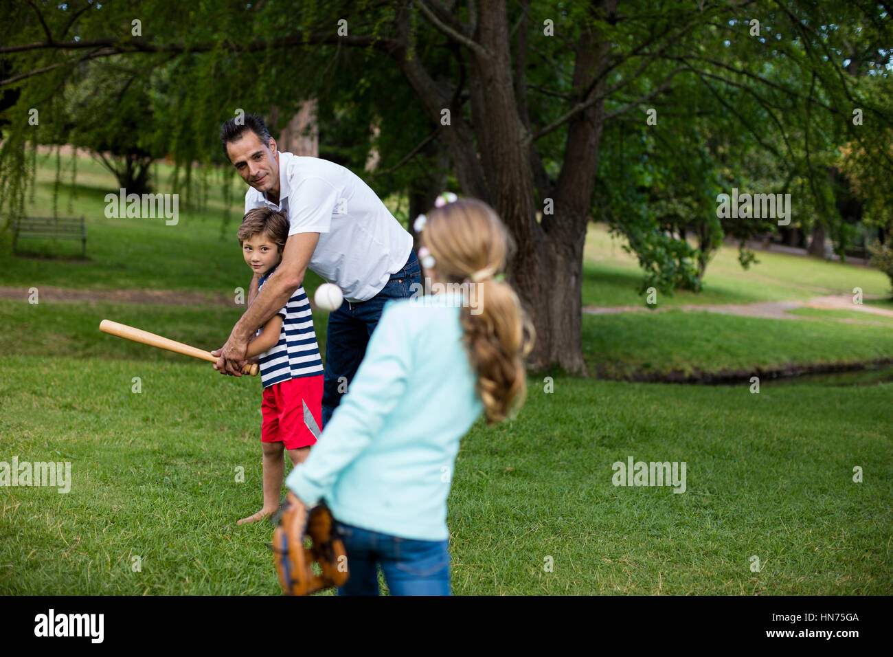 Happy family playing baseball in the park Stock Photo - Alamy