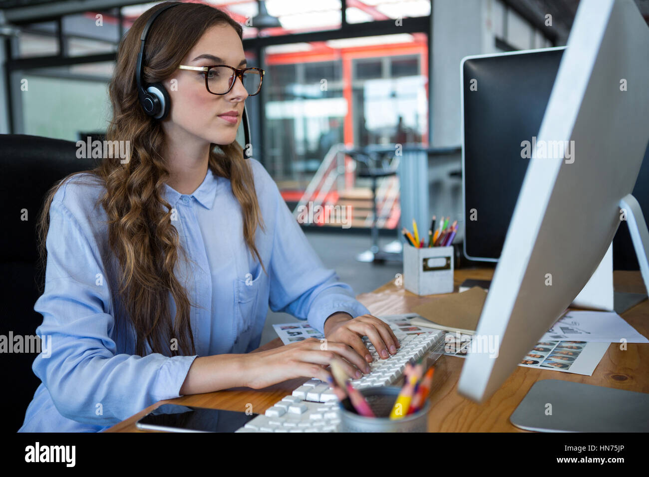 Female graphic designer working over computer at desk in office Stock ...