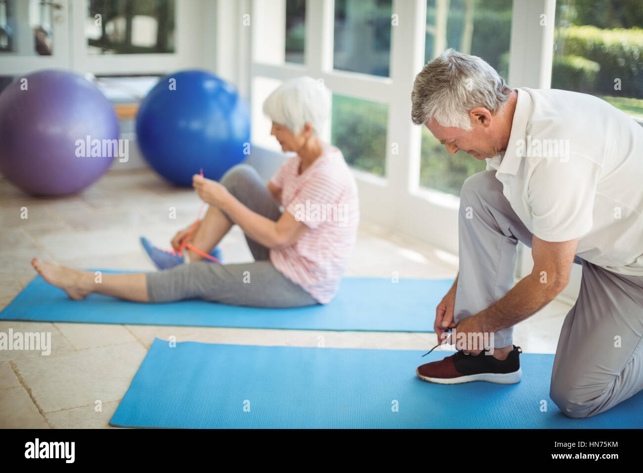 Happy senior couple removing their shoes at home Stock Photo - Alamy