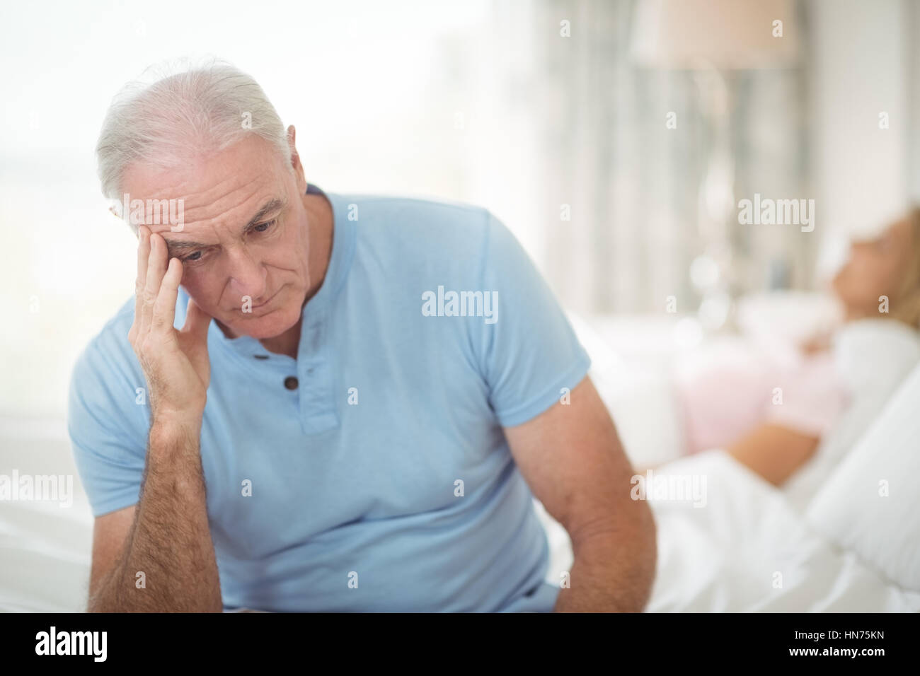 Worried senior man sitting in bedroom at home Stock Photo - Alamy