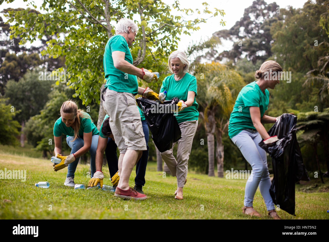Team of volunteers picking up litter in park Stock Photo - Alamy