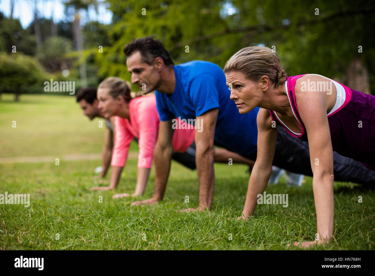 Group of people performing stretching exercise in park Stock Photo - Alamy