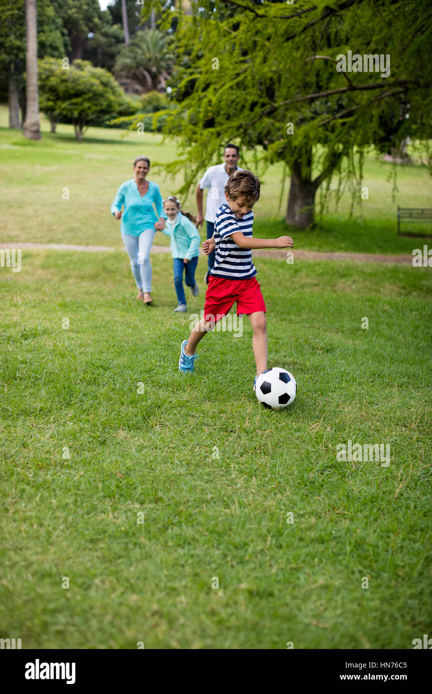 Happy family playing football in the park on a sunny hi-res stock ...
