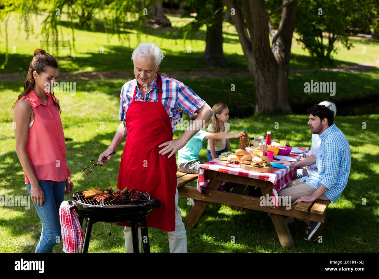 Family preparing barbeque in park Stock Photo - Alamy