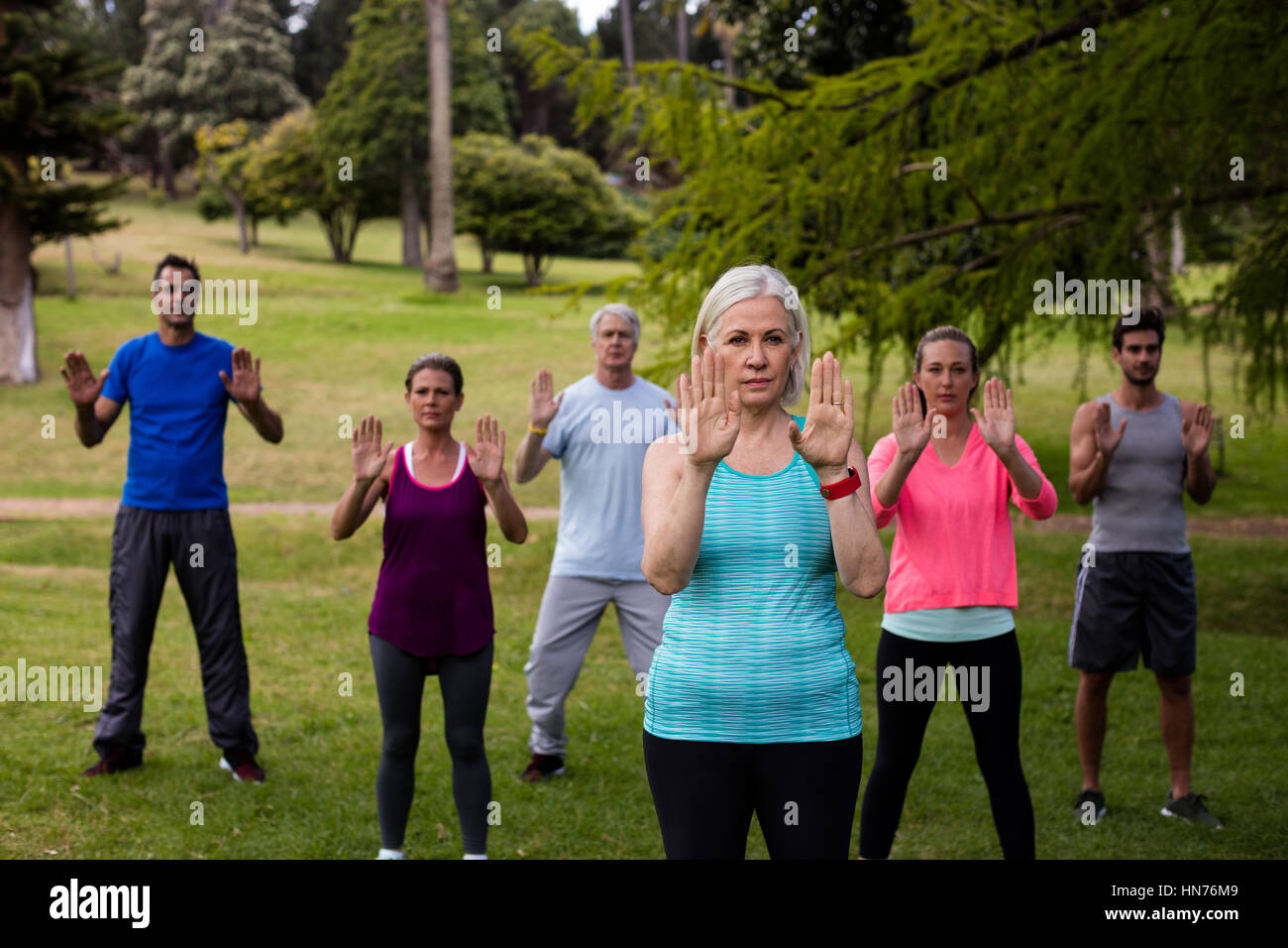 Group of people exercising together in park Stock Photo - Alamy
