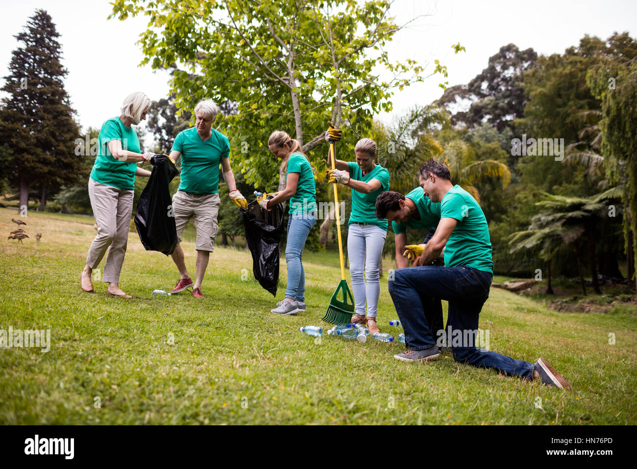 Team of volunteers picking up litter in park Stock Photo - Alamy