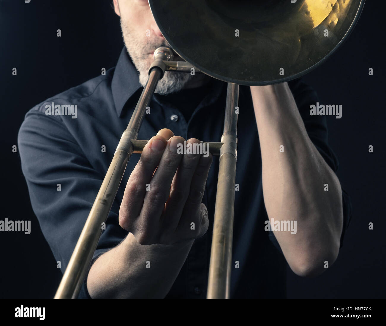 Close up of a musician with an old dusty trombone on a dark background ...