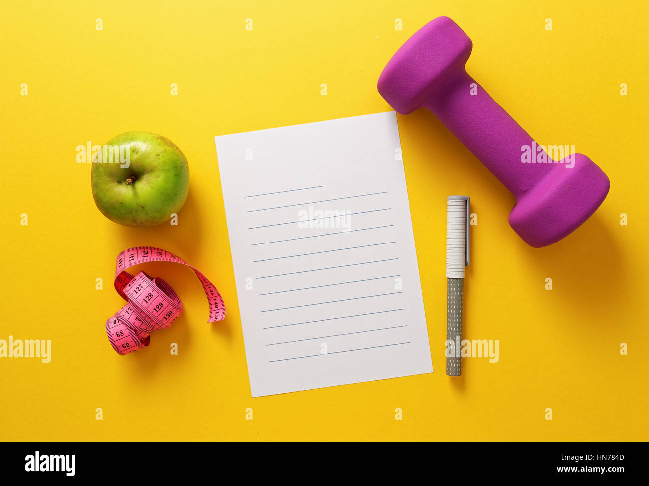 Healthy lifestyle and sports. Blank lined paper with pen, dumbbells ...