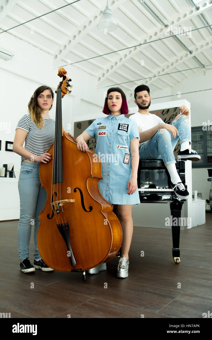 Group of musicians standing in front of grand piano holding instruments ...