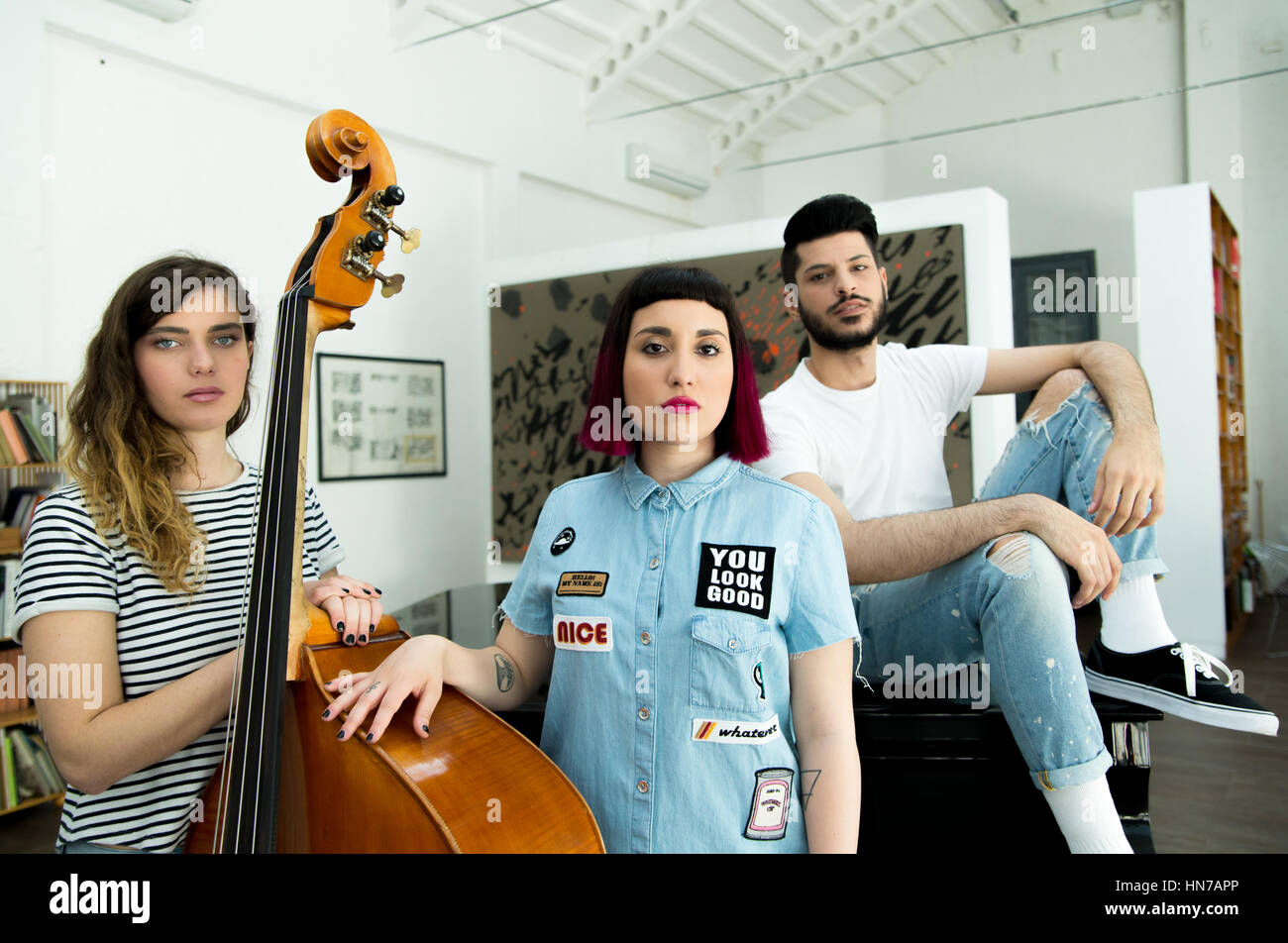 Group of musicians standing in front of grand piano holding instruments ...
