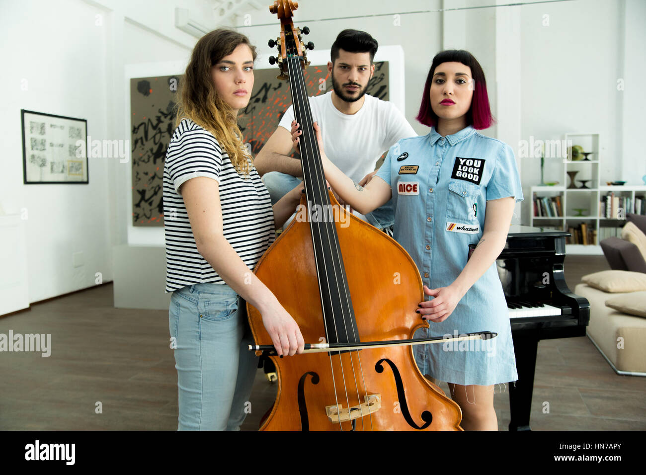 Group of musicians standing in front of grand piano holding instruments ...