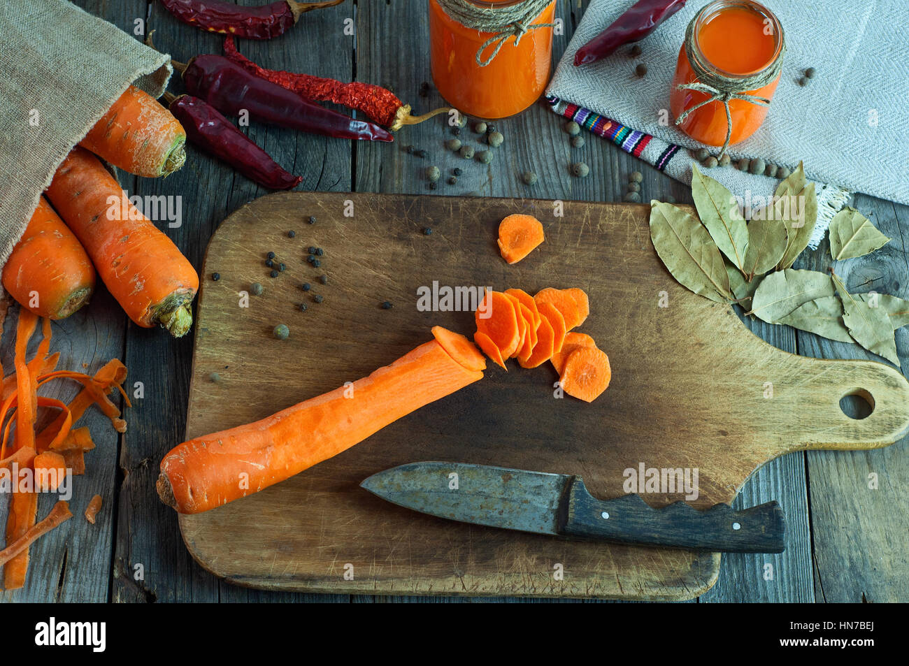 Cut into round slices of a big fresh carrots on a chopping board in the ...