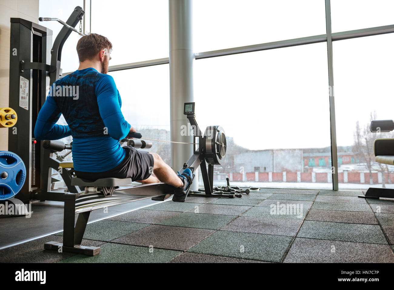 Back view picture of handsome young sportsman in gym make sport ...