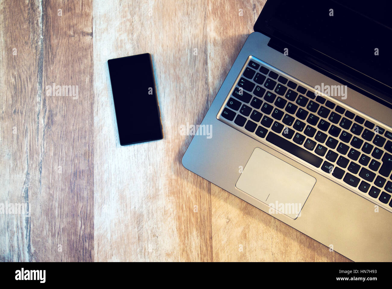 Smartphone and laptop computer on office desk, top view Stock Photo - Alamy