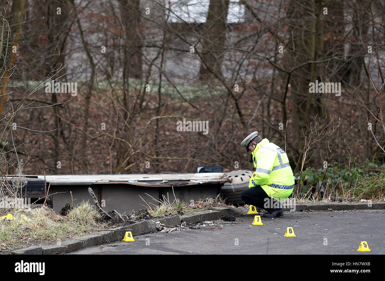 Crash investigators put markers on the road at the scene where a school ...