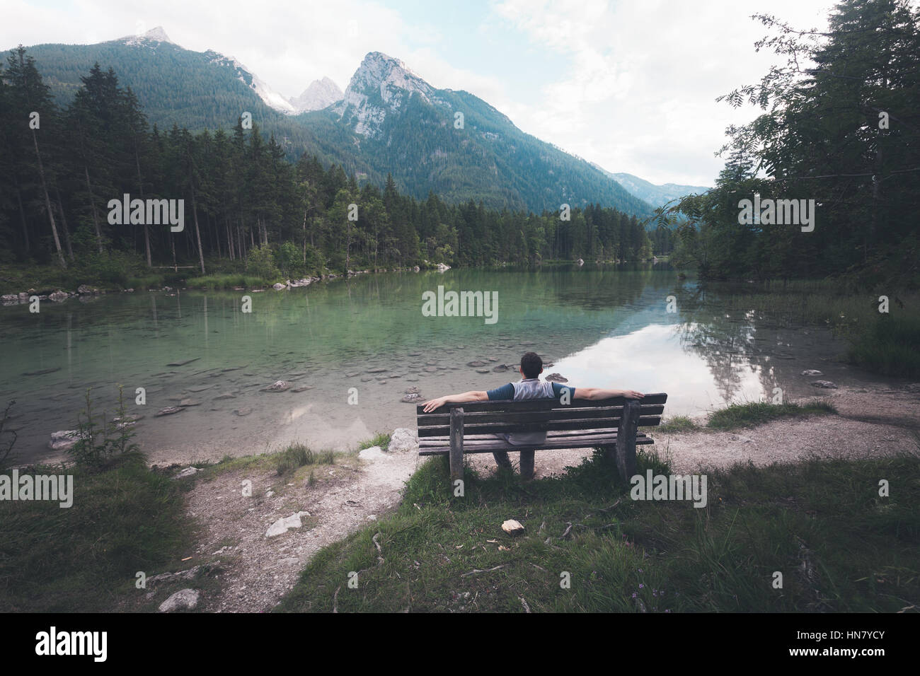 Man sitting near the mountain lake Stock Photo - Alamy