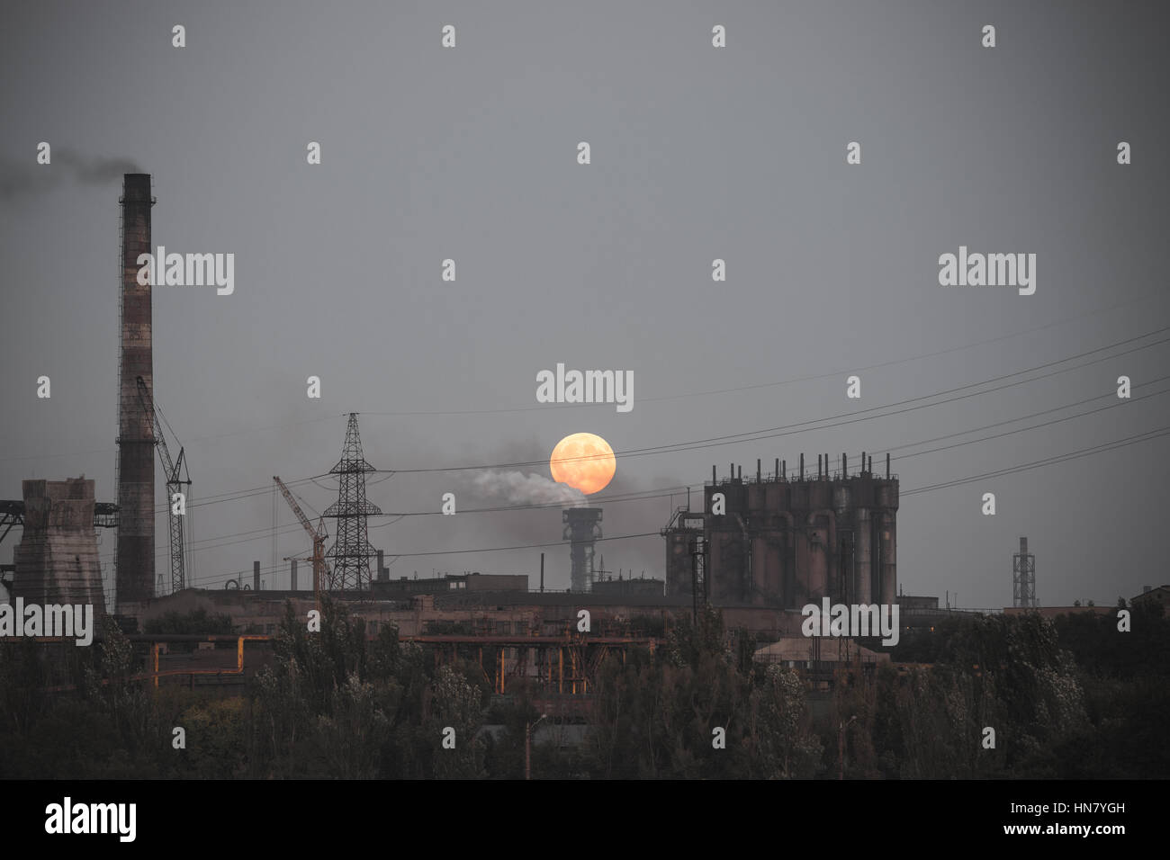 Panorama of full moon rising over industrial landscape Stock Photo - Alamy