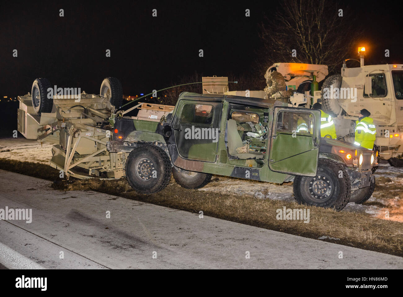 A US military vehicle with a toppled trailer seen next to a lane after ...