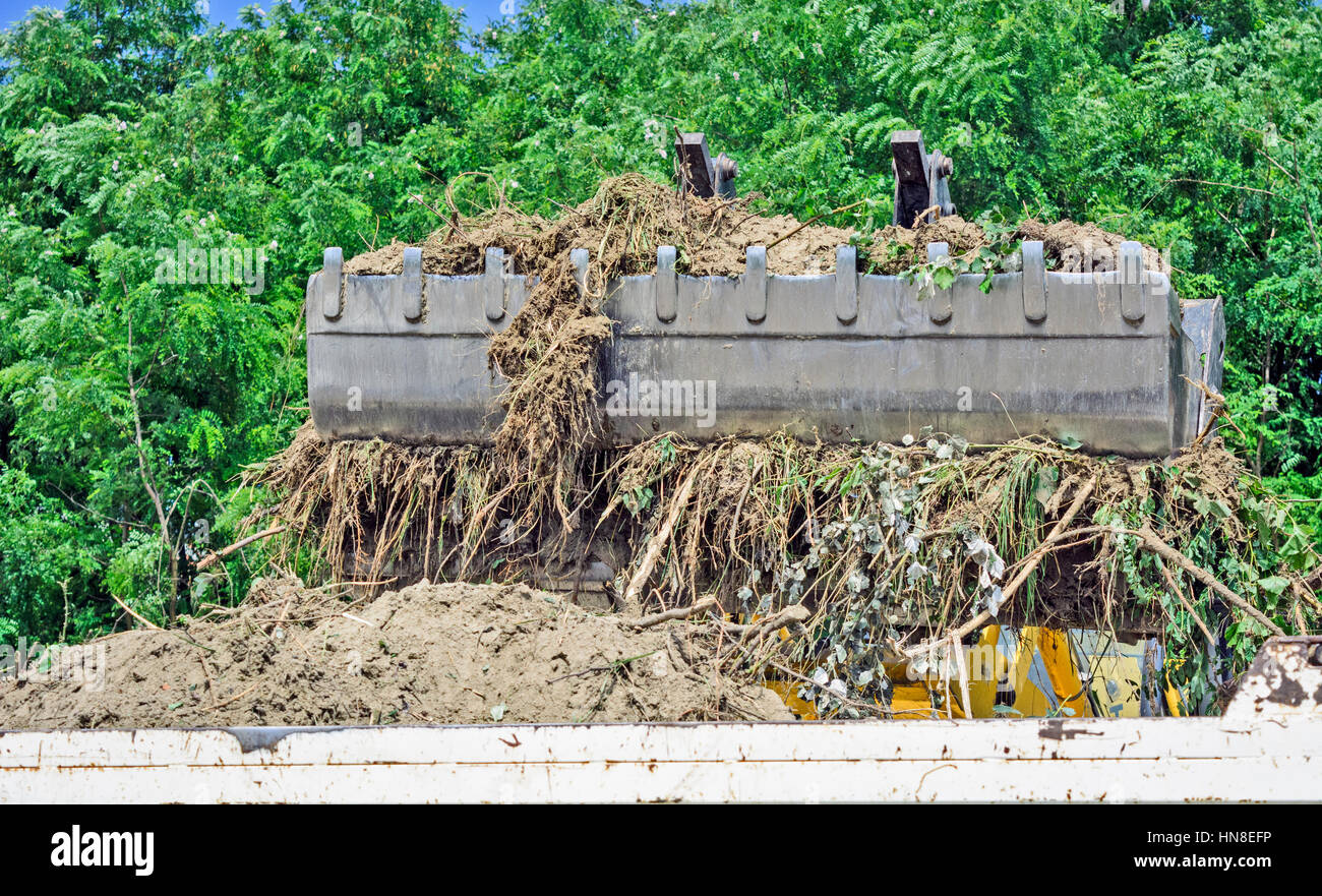Excavator with bucket loading sand and rubble for removal Stock Photo ...