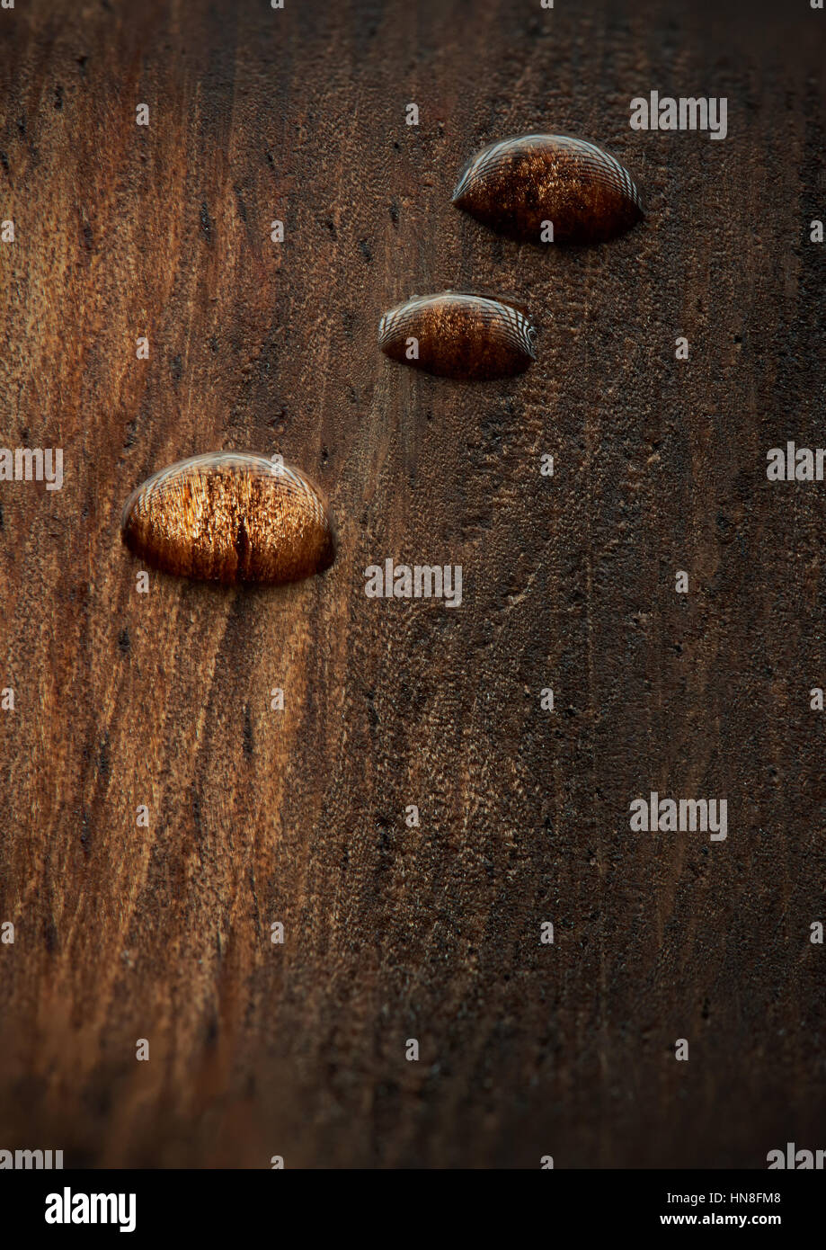 macro of three water drops on dark wood texture Stock Photo - Alamy