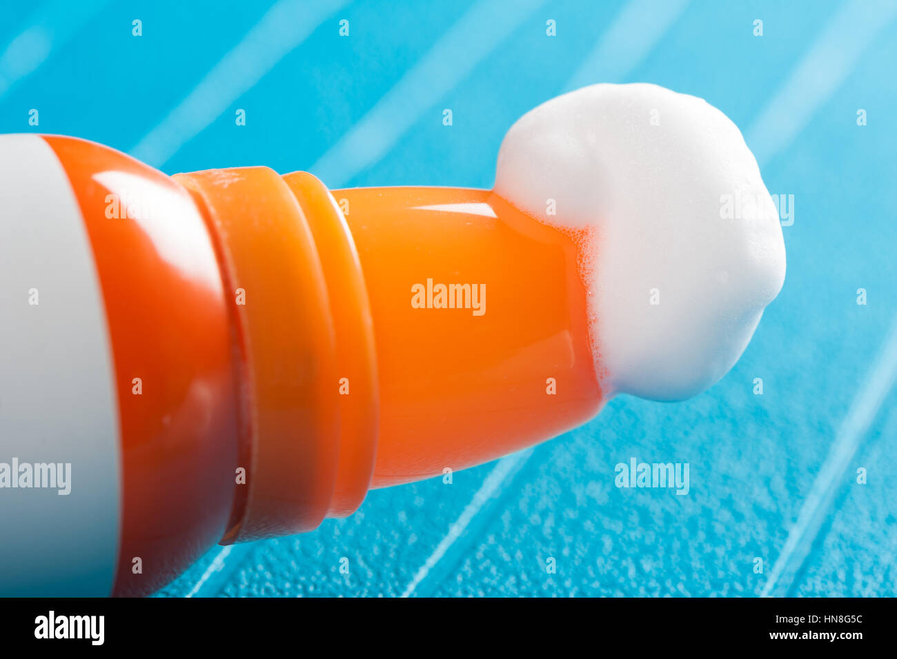 closeup white hair mousse on blue background Stock Photo - Alamy