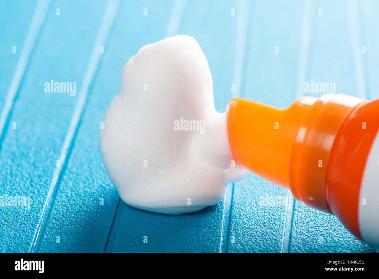 closeup white hair mousse on blue background Stock Photo - Alamy