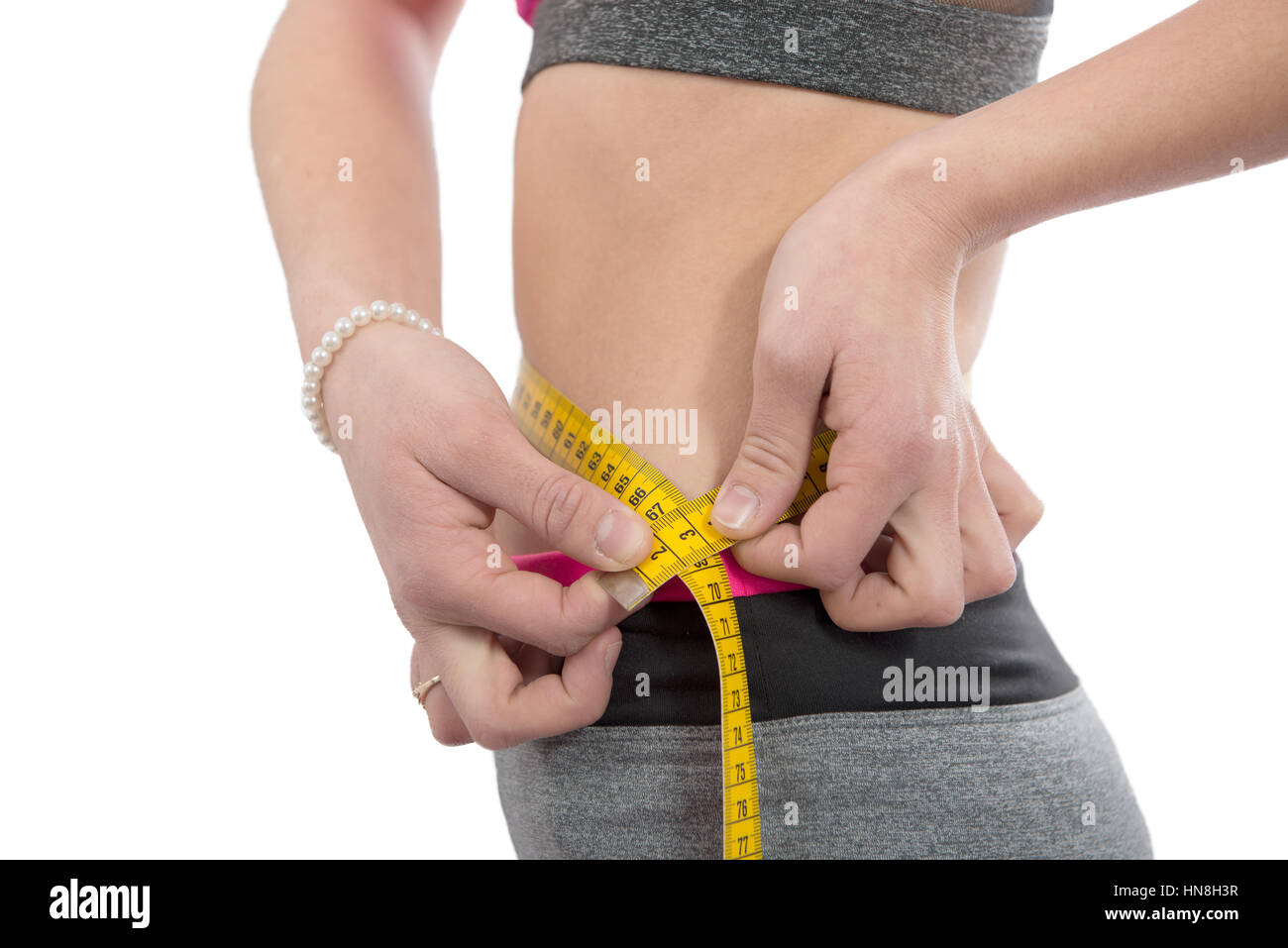 woman measuring her waist with a measure tape isolated on white ...