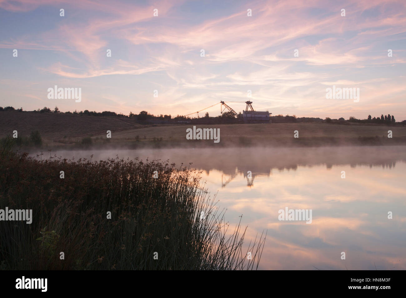 Dragline (known as 'Oddball') at sunrise with mist over water, at site ...