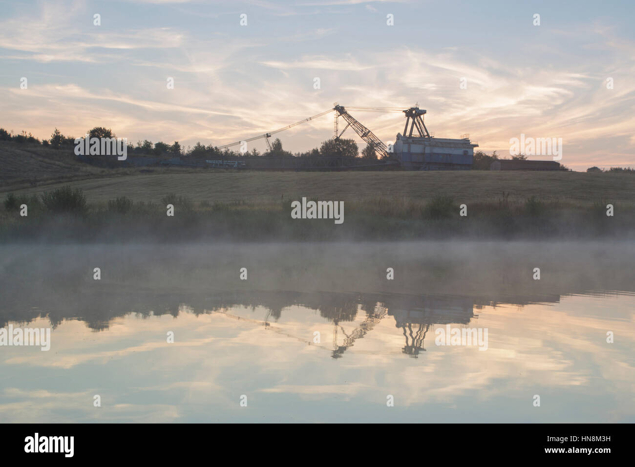 Dragline (known as 'Oddball') at sunrise with mist over water, at site ...