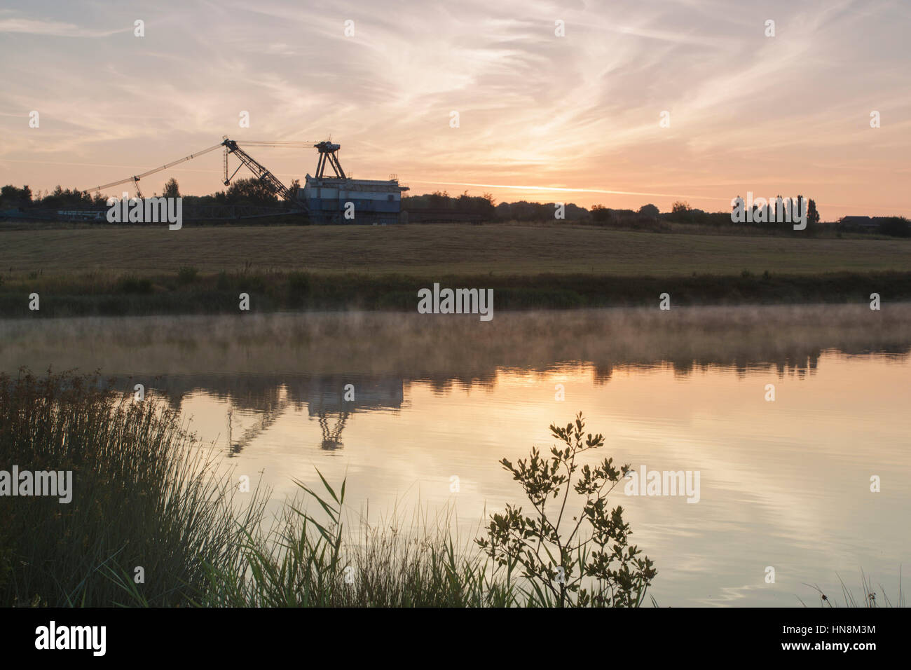 Dragline (known as 'Oddball') at sunrise with mist over water, at site ...