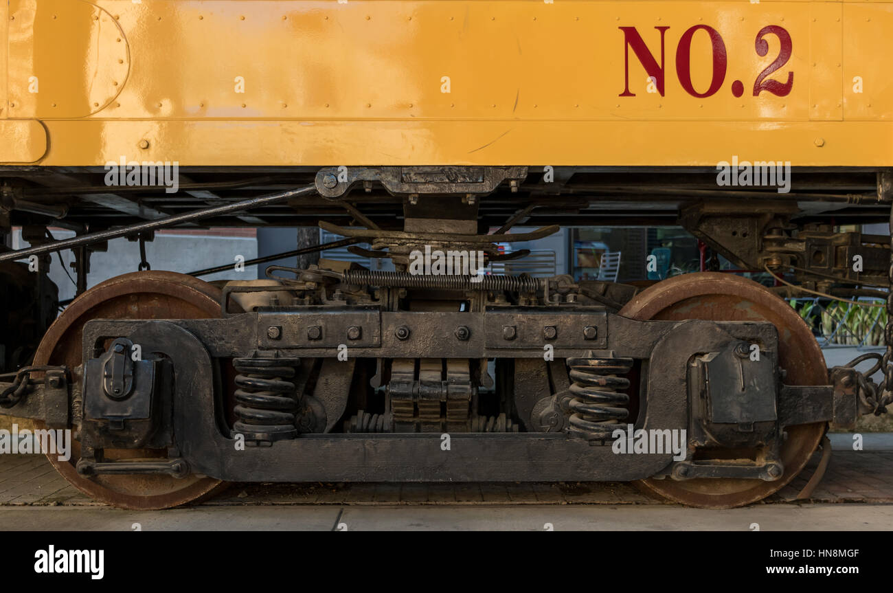 Section of Train Wheels underneath yellow car Stock Photo - Alamy