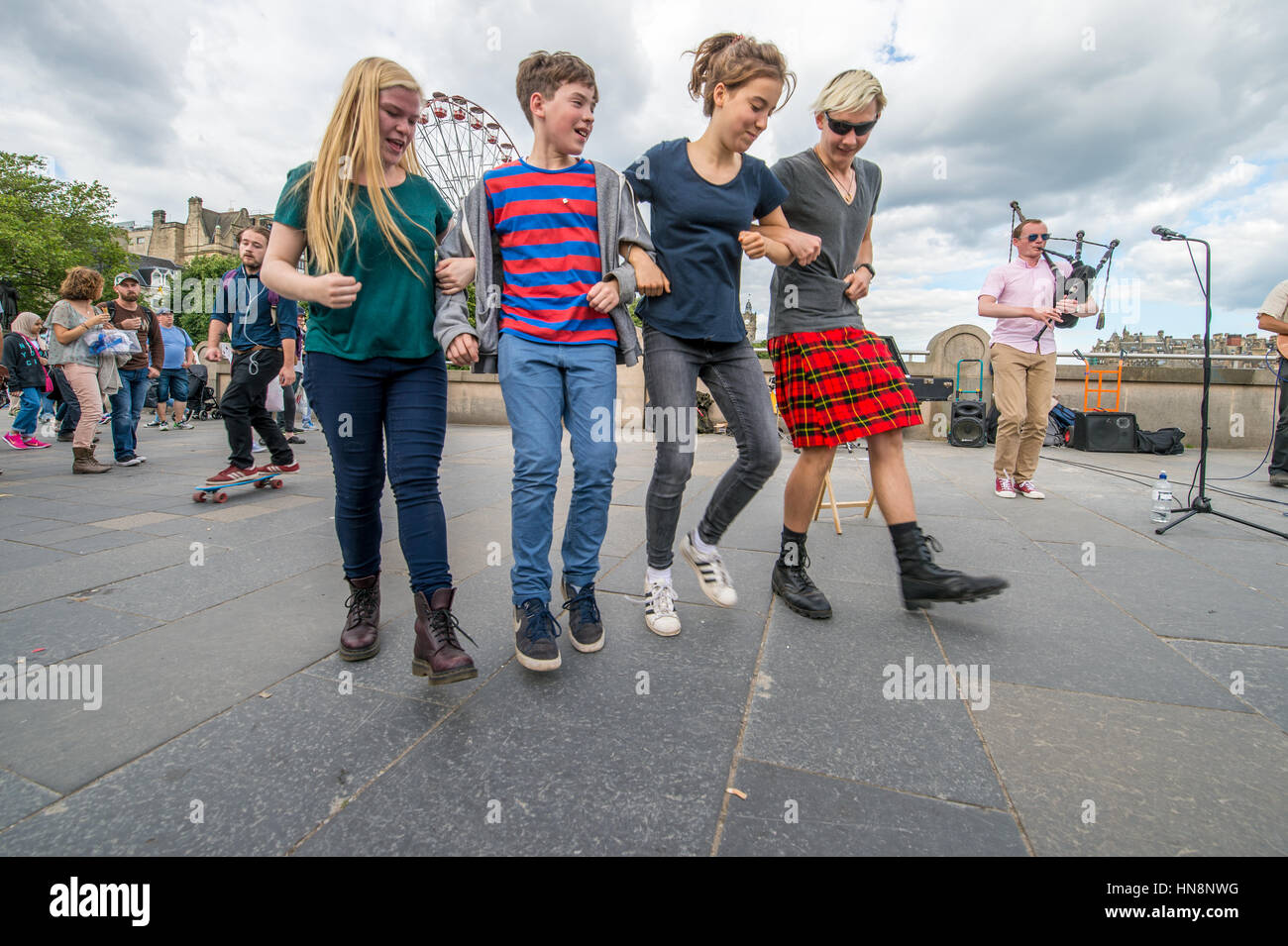 UK, Scotland, Edinburgh - A young group of locals dancing while a local ...