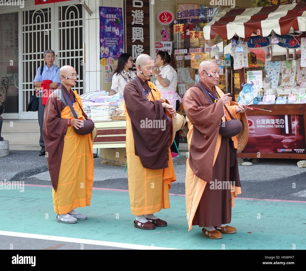KAOHSIUNG, TAIWAN -- OCTOBER 15, 2016: Three Buddhist monks prepare to ...