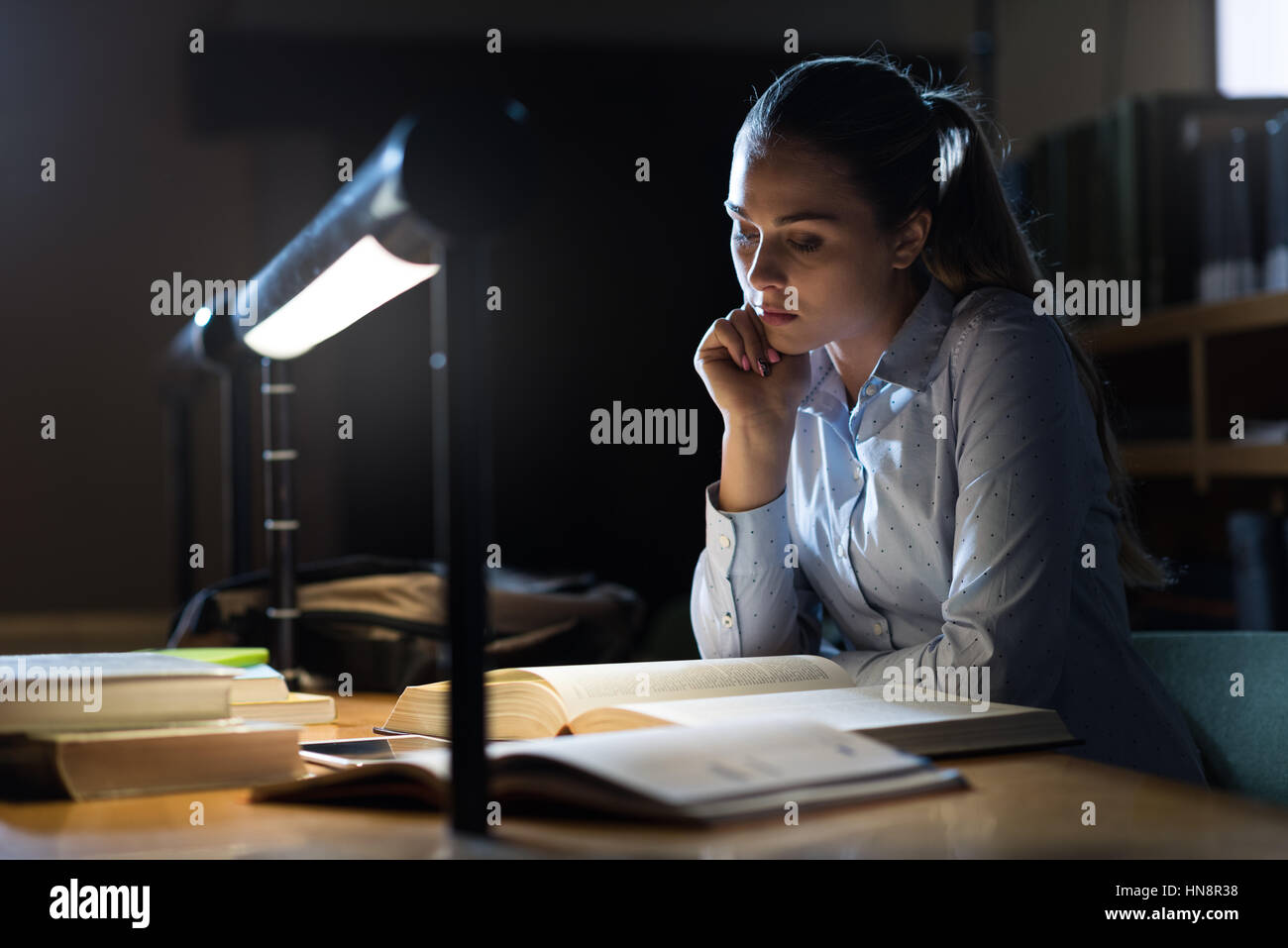 Efficient student girl studying late at night at the library, education ...