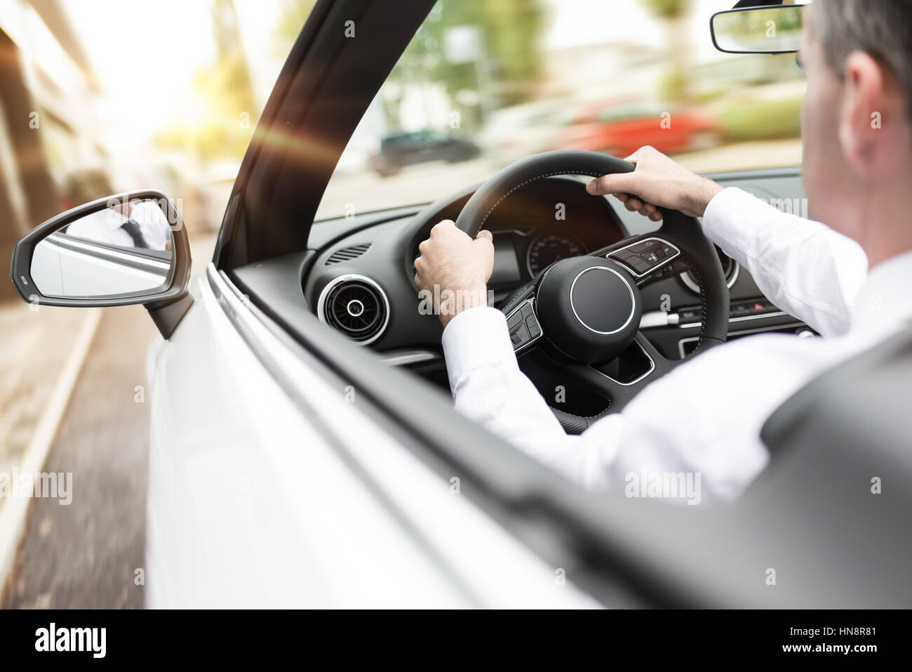 Successful businessman driving his car, hands on steering wheel close ...