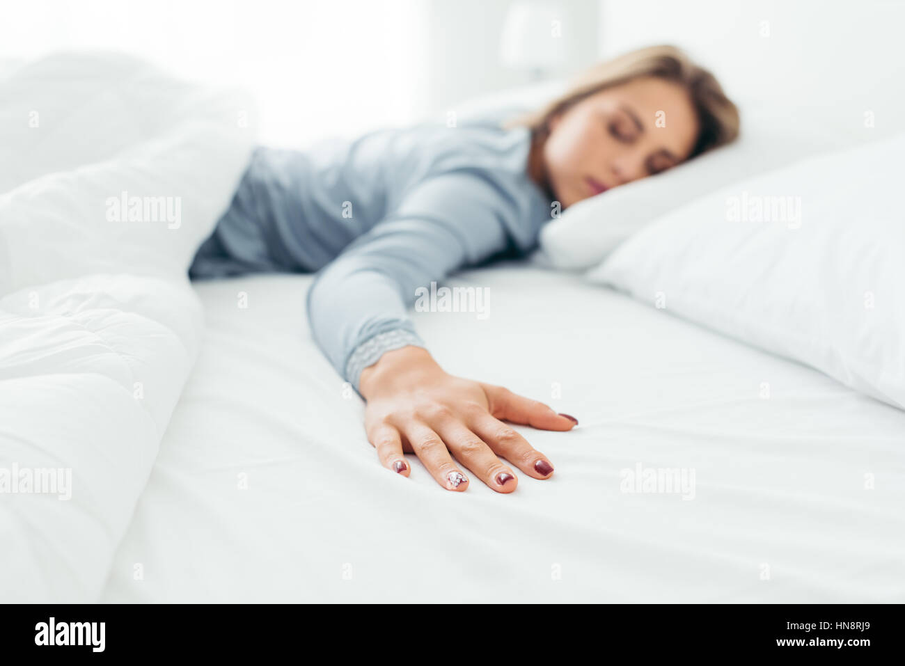 Lonely young woman sleeping in her bed and missing her partner, she ...