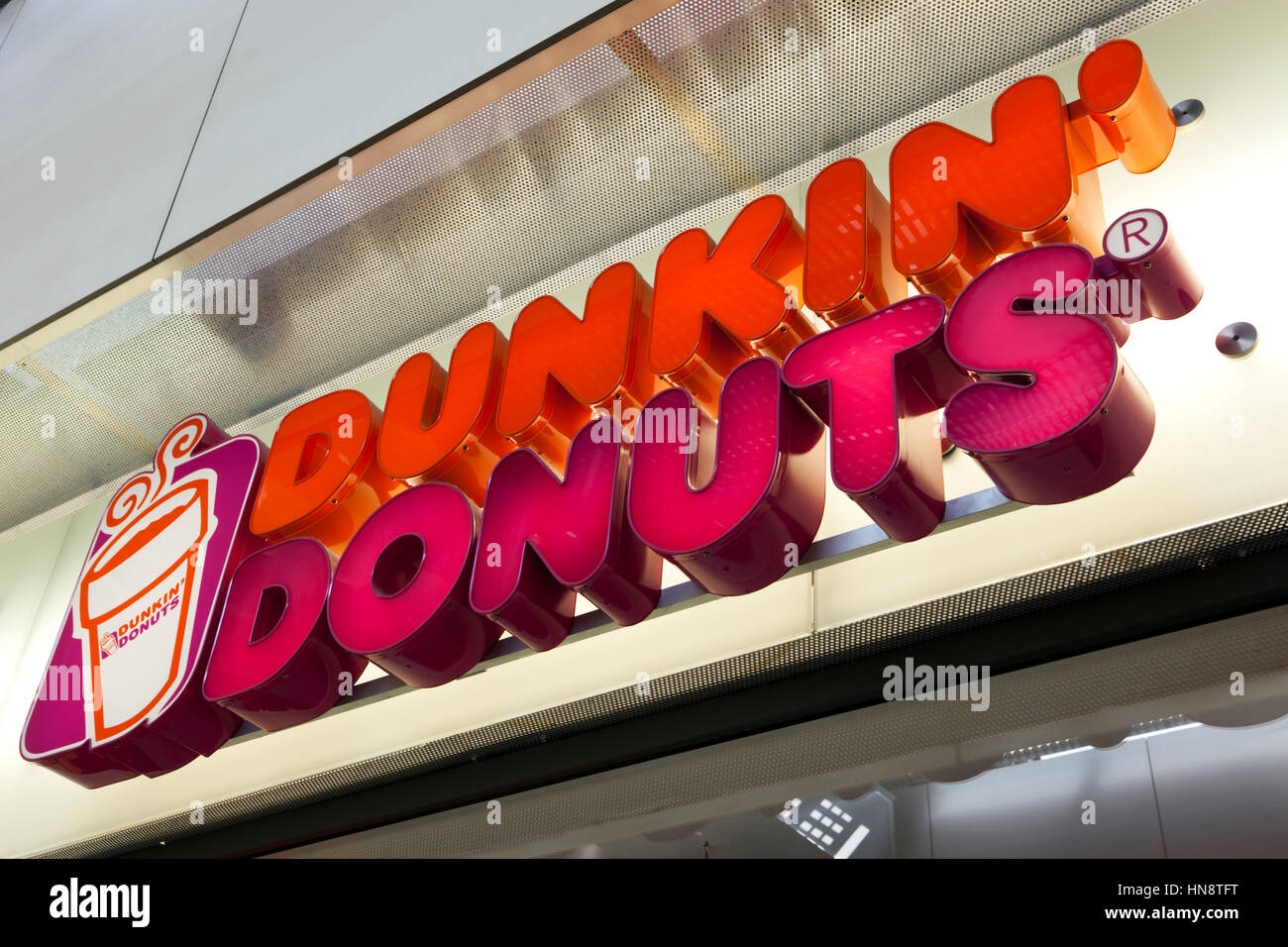 Dunkin' Donuts sign at shop entrance. Dunkin' Donuts is an ...