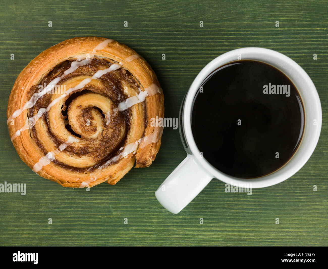 Iced Cinnamon Swirl Danish Pastry With a Mug of Black Coffee Stock ...