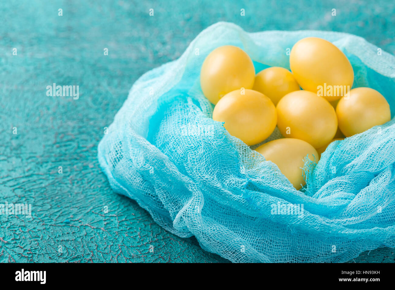 Yellow Easter eggs on a turquoise background Stock Photo - Alamy
