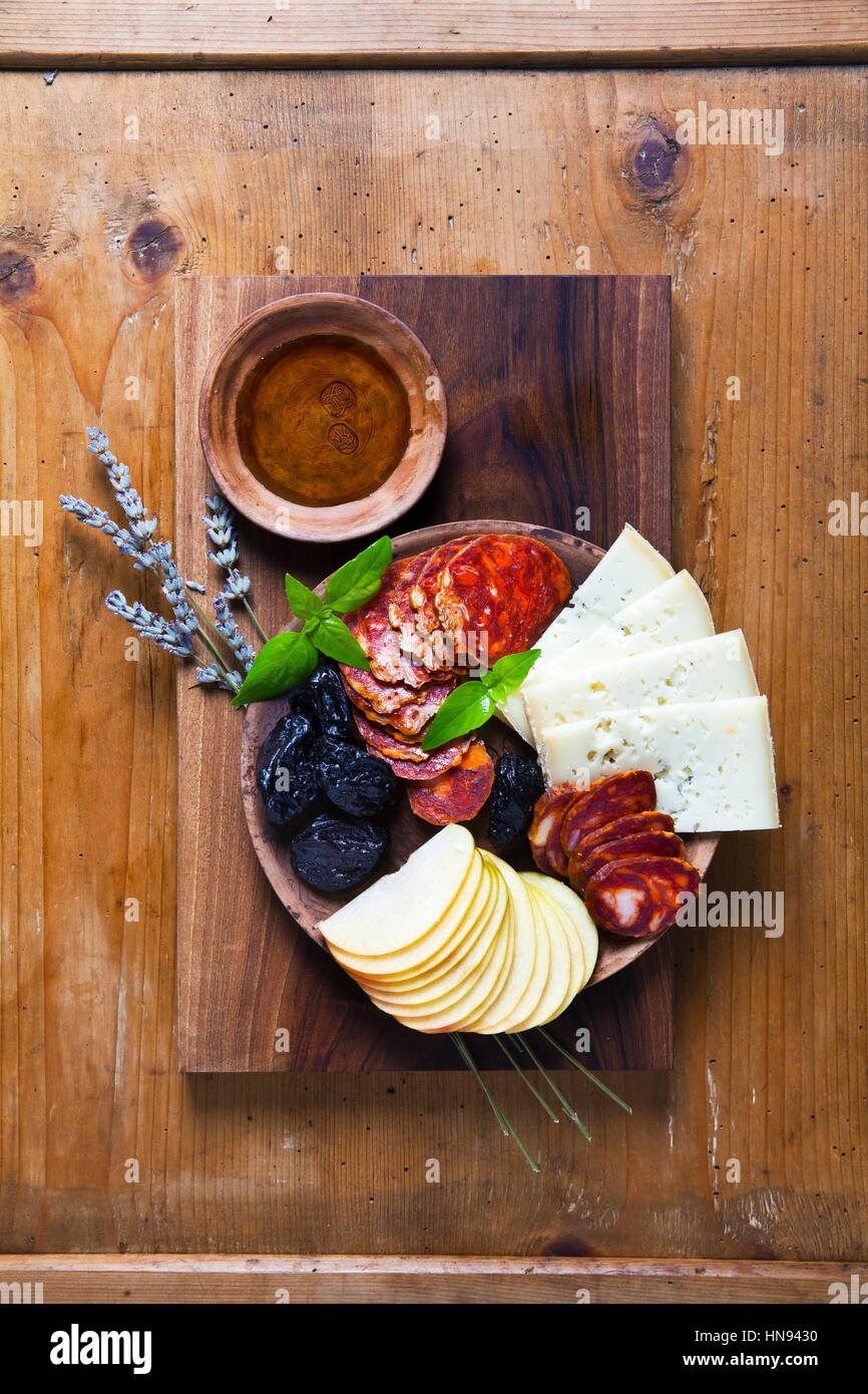 Snack on a clay plate and wooden background. rural style. prosciutto ...
