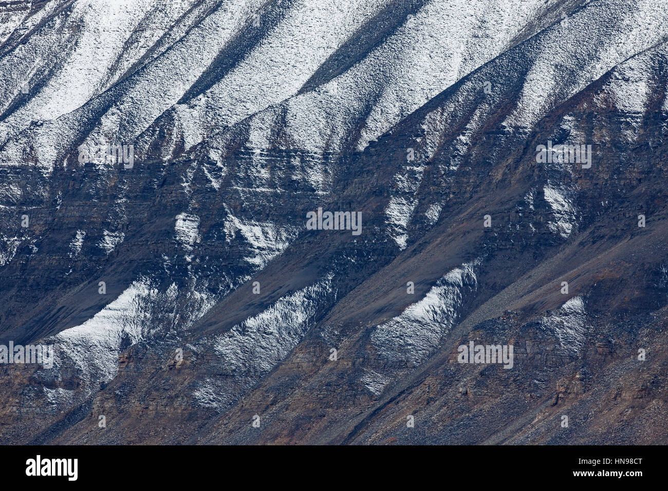 Snow covered eroded mountain slope at Adventdalen, Longyearbyen ...