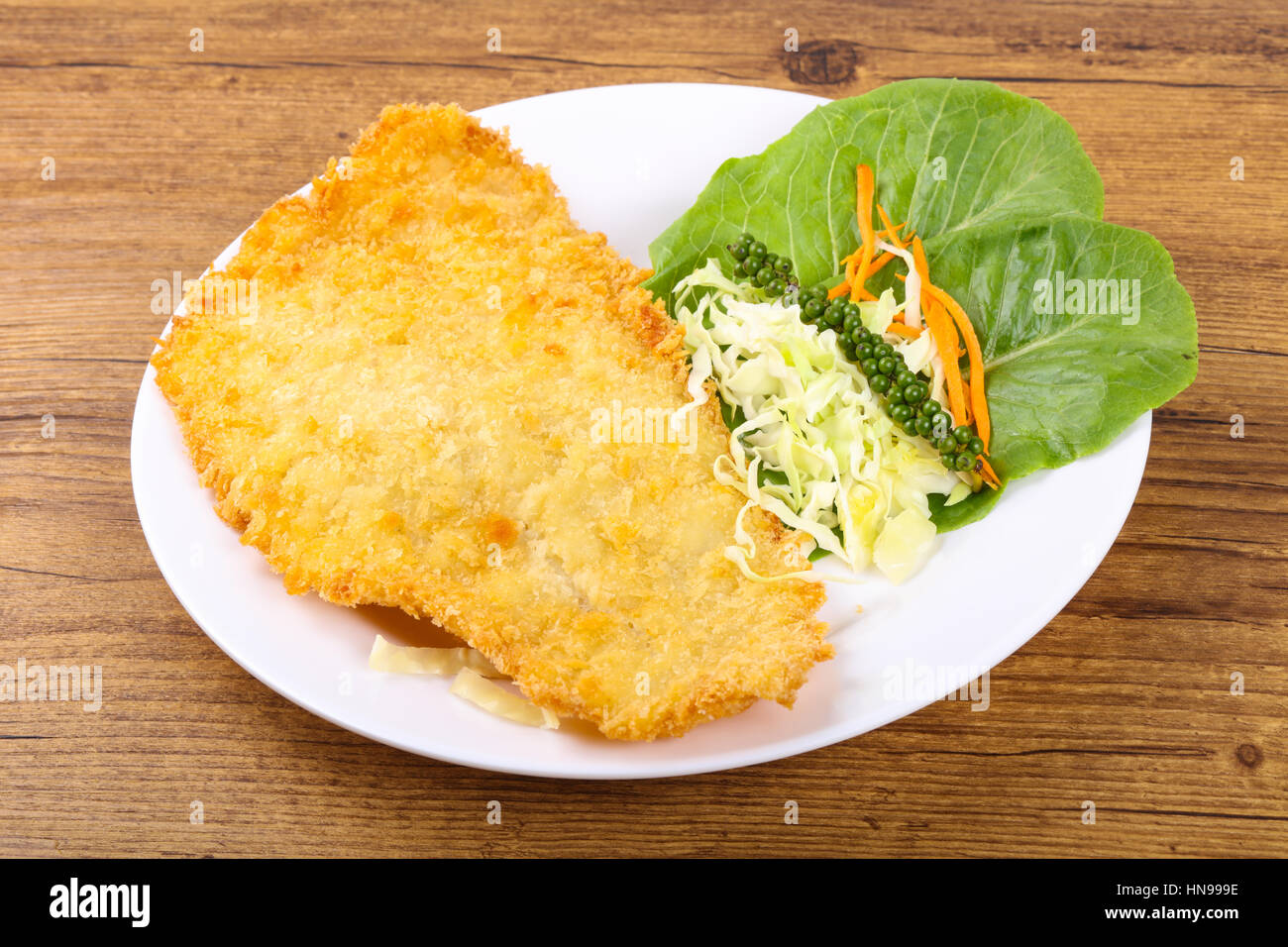 Fried Dory fish with salad on the wood background Stock Photo - Alamy