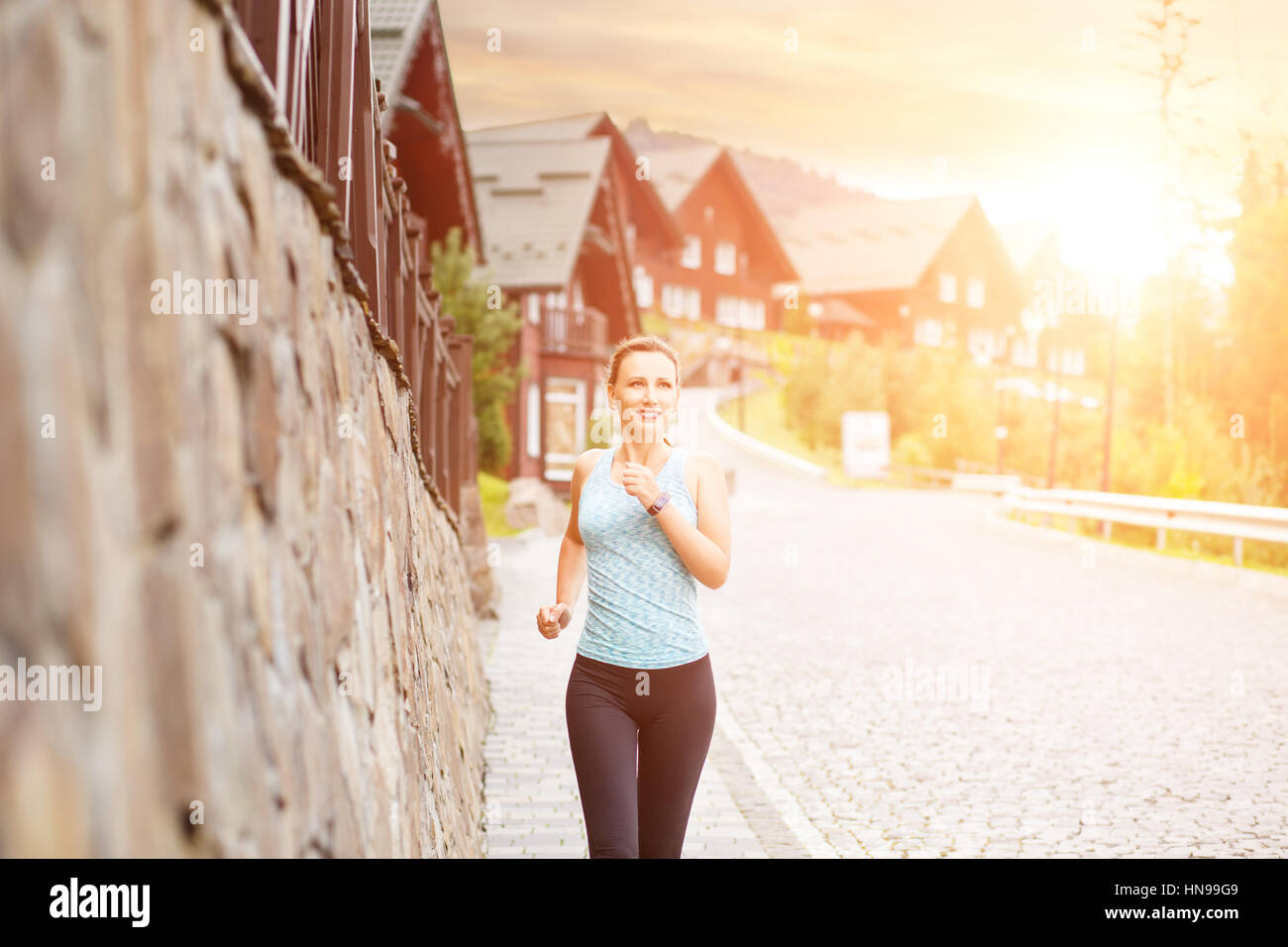 Young athletic girl running on the road in the morning. Attractive ...