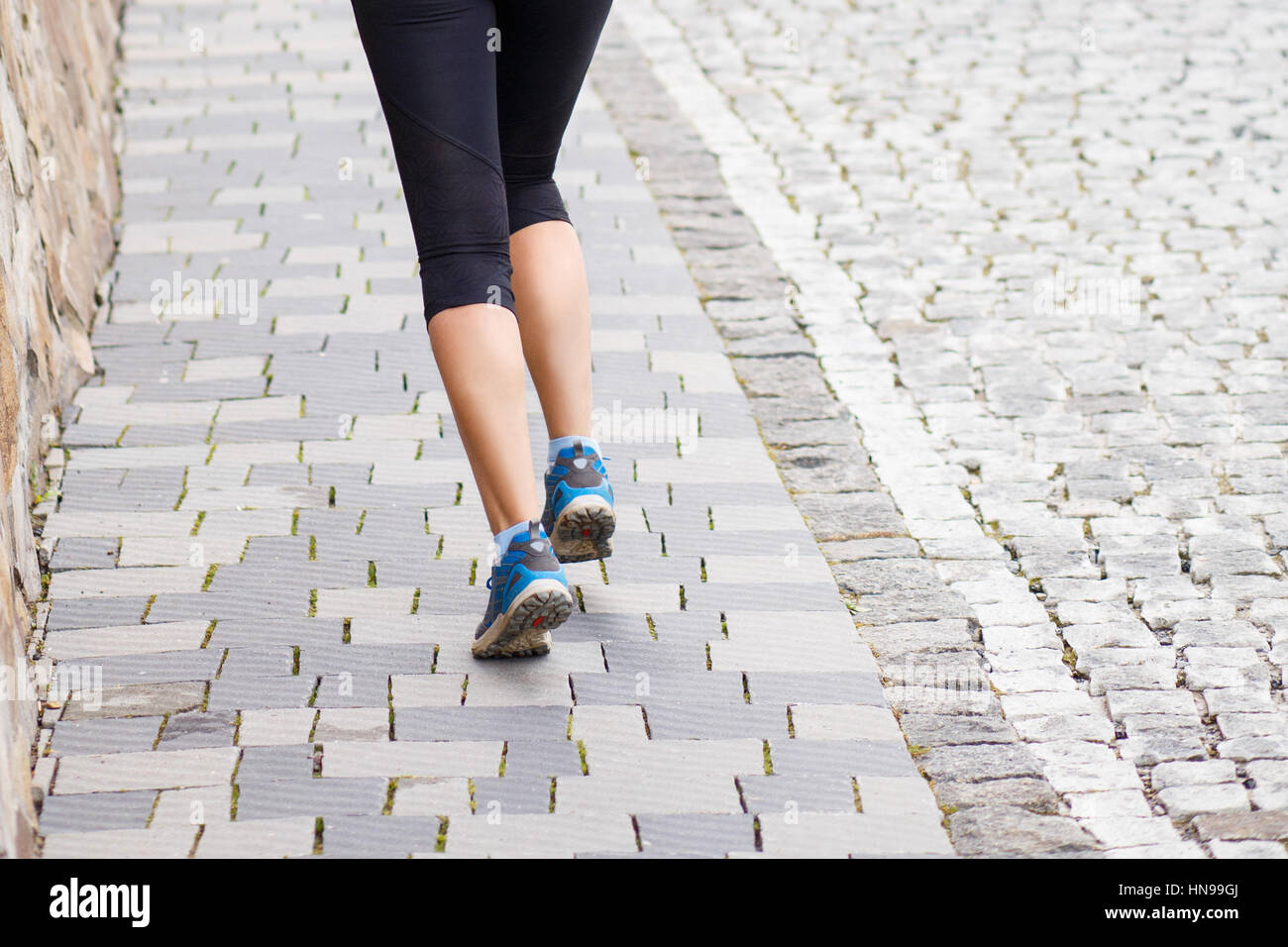 Running woman legs on cobbled road or street. Close up fitness ...
