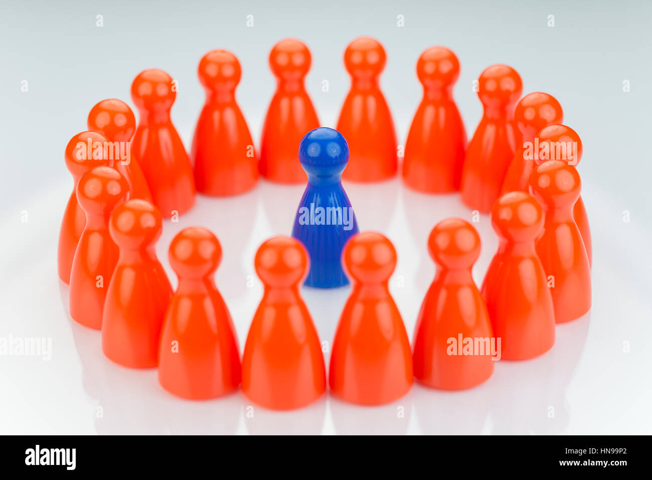 Conceptual orange game pawns and a blue play pawn as abstract display ...