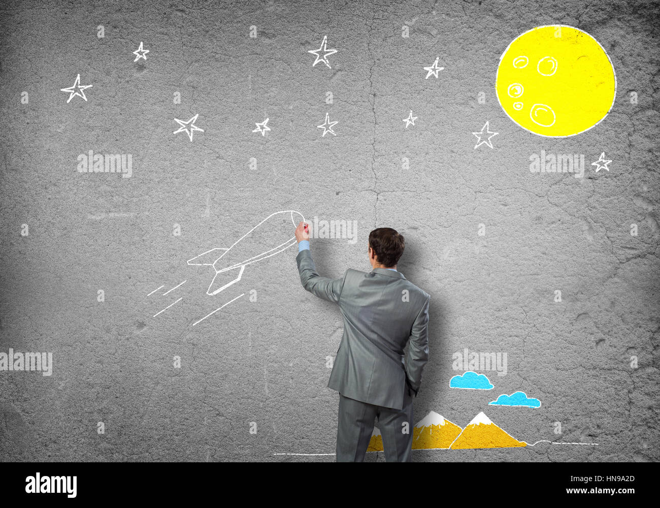 Rear view of businessman drawing rocket on wall Stock Photo - Alamy