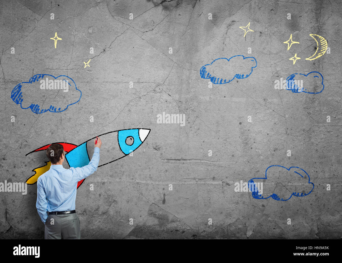 Rear view of businessman drawing rocket on wall Stock Photo - Alamy