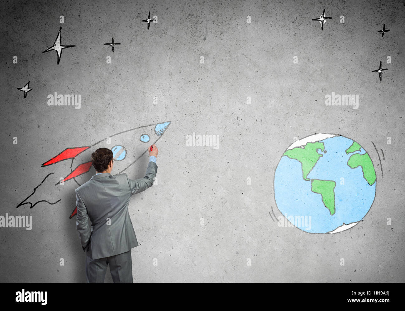 Rear view of businessman drawing rocket on wall Stock Photo - Alamy